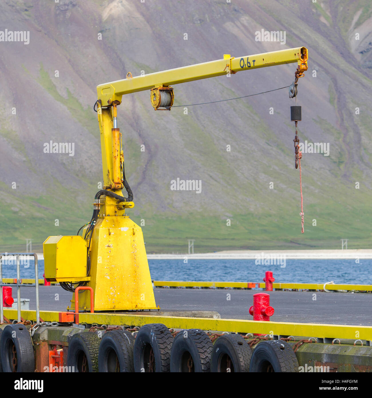 Yellow fishing crane in small seaside Iceland town harbor Stock Photo ...