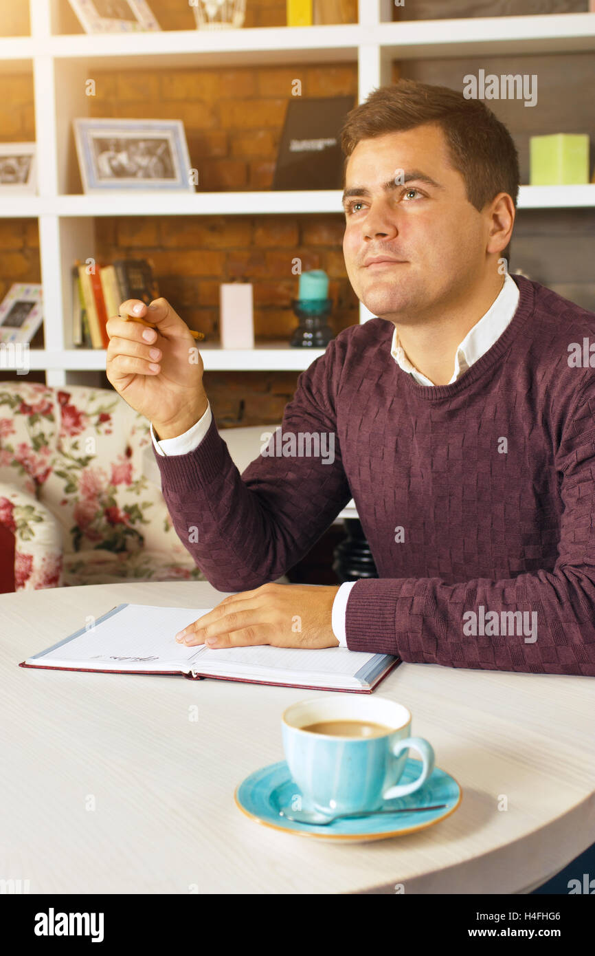 Man holding pencil and writing on a paper in the diary Stock Photo - Alamy