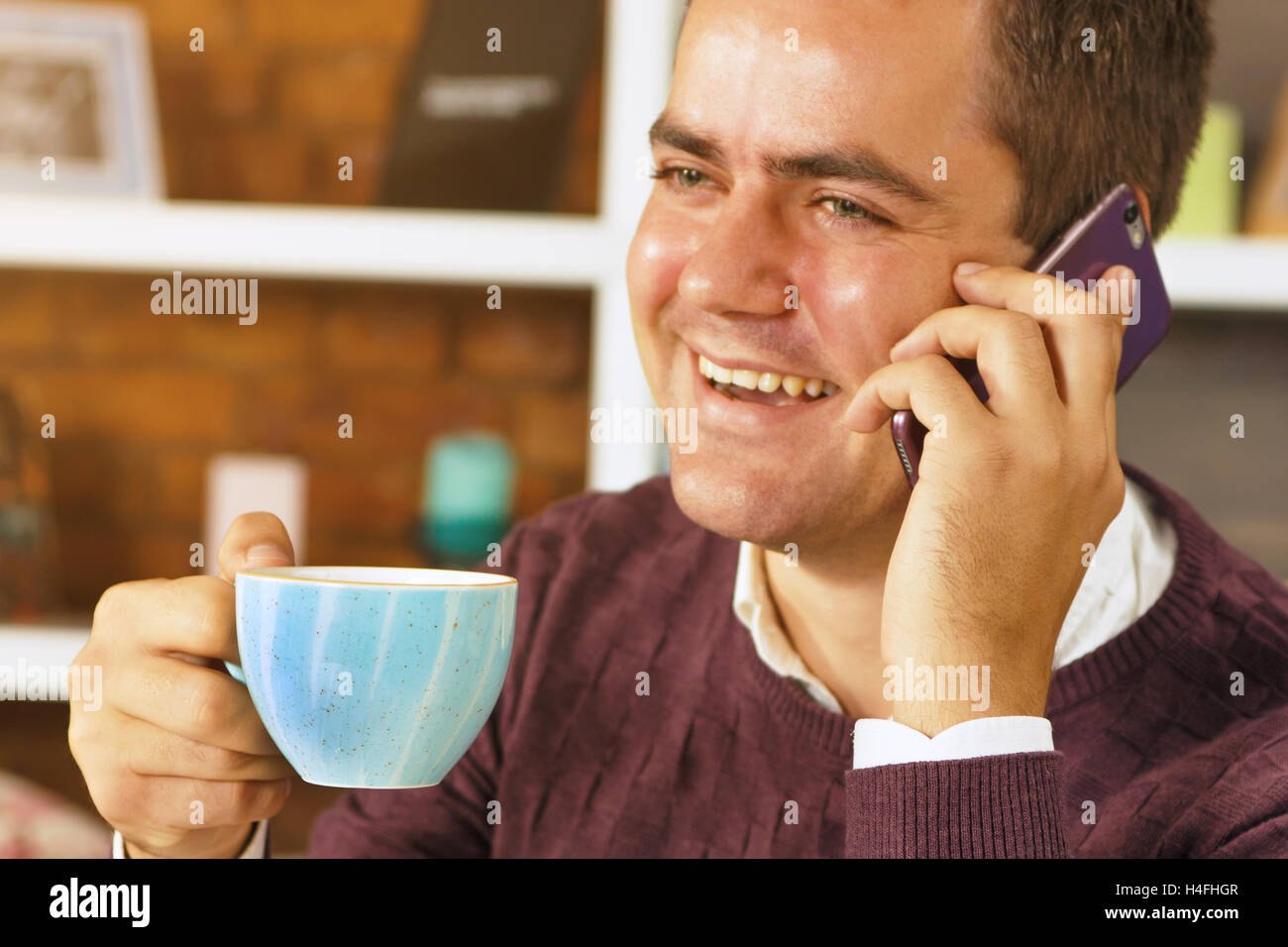Man drinking coffee and talking on the phone Stock Photo - Alamy
