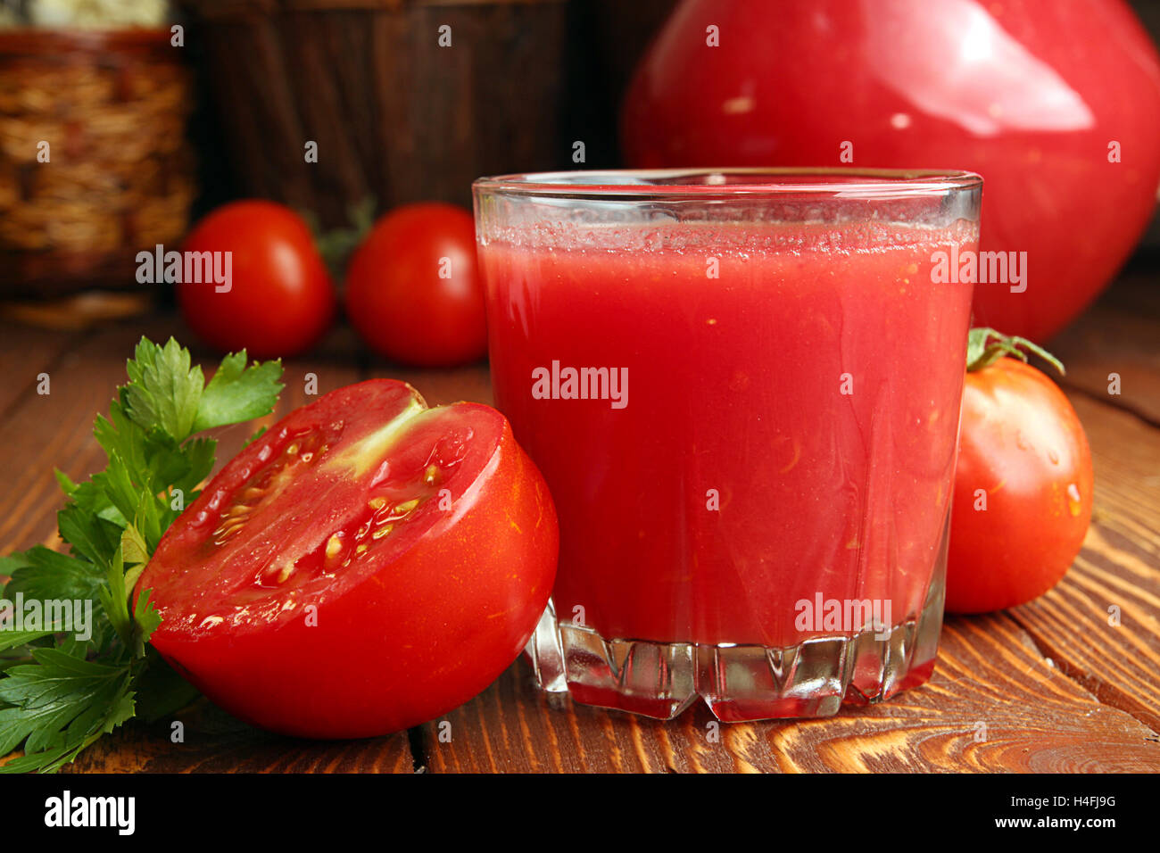 Glass of tomato juice and fresh tomatoes on old wooden table Stock ...