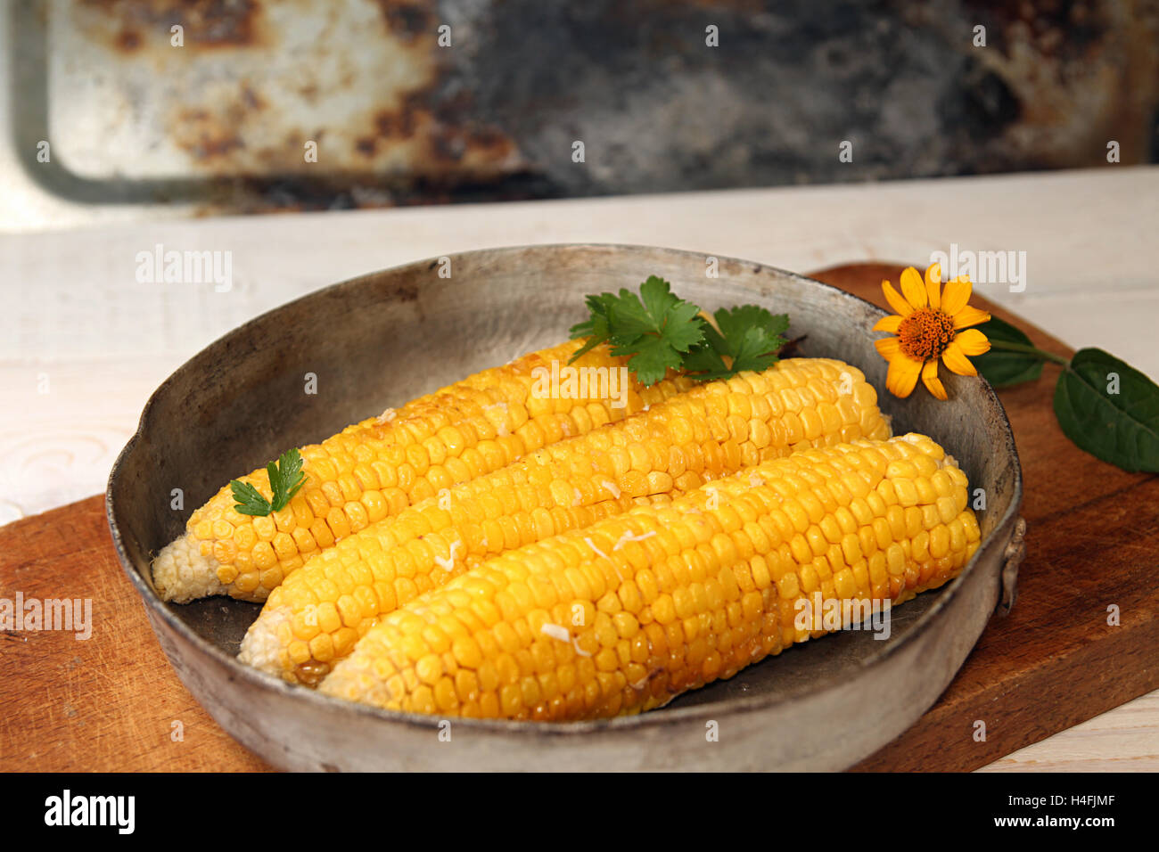 Corn baked in oven with butter and garlic - in old pan. Vintag ...