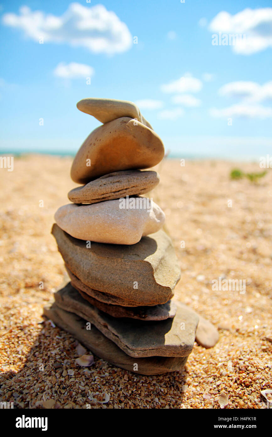The balanced design of seashore stones on the beach against the sand ...