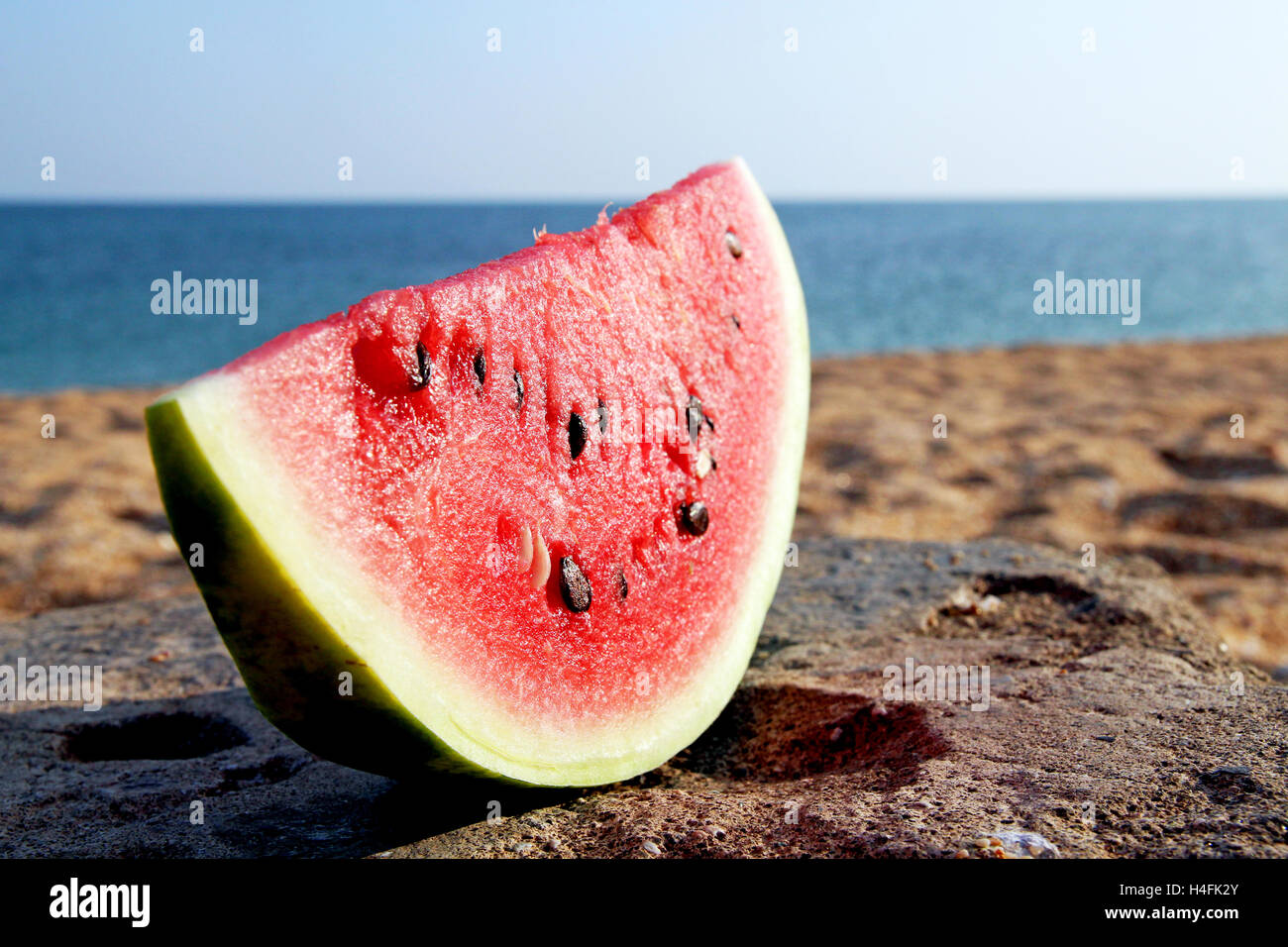 A slice of the watermelon on the stone on the beach Stock Photo - Alamy