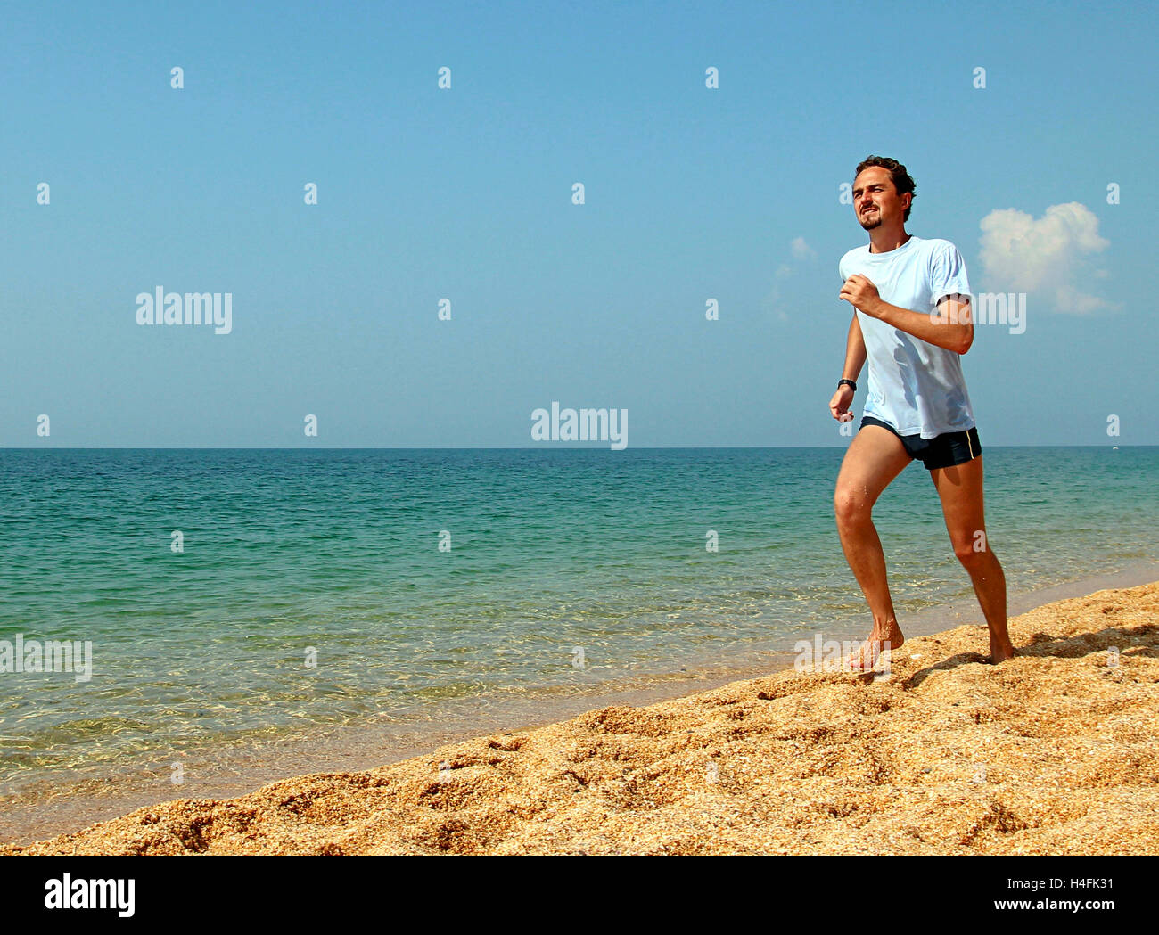 The man running at the beach against the sea and the sky Stock Photo ...