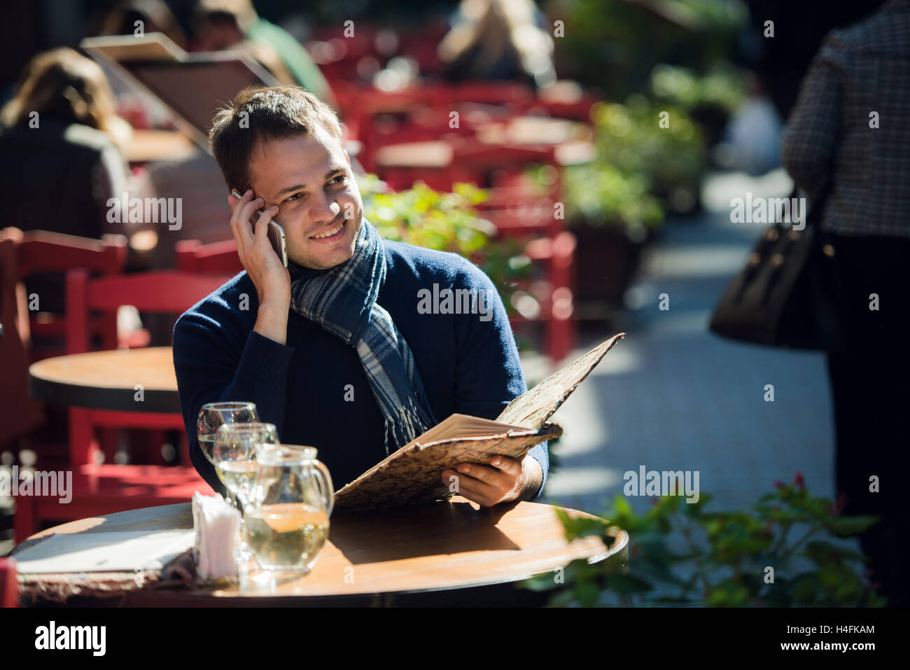 Man on cafe with smartphone talking and ordering something. Handsome ...