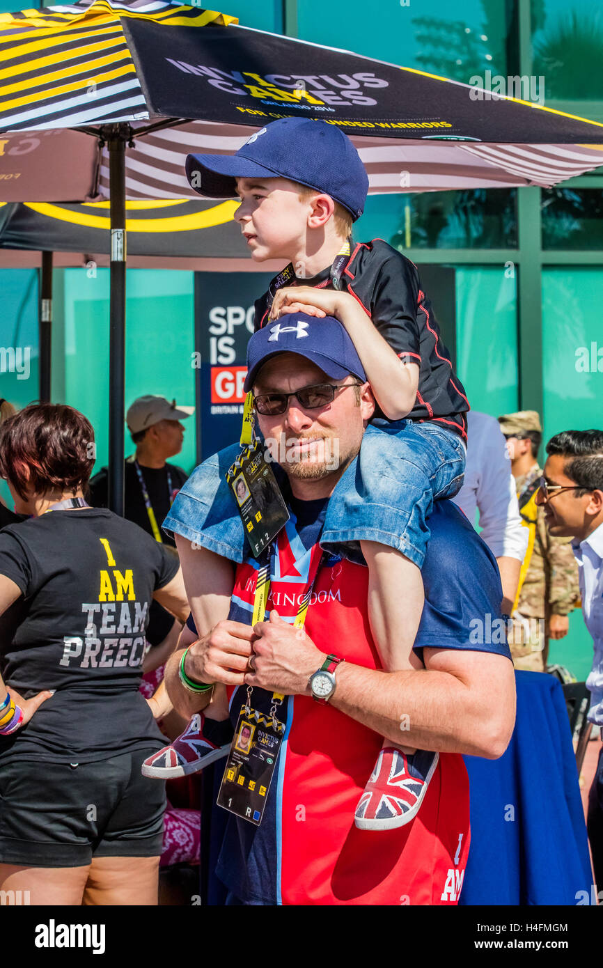 Competitor Matthew Elliott, from the United Kingdom, carries his son on ...