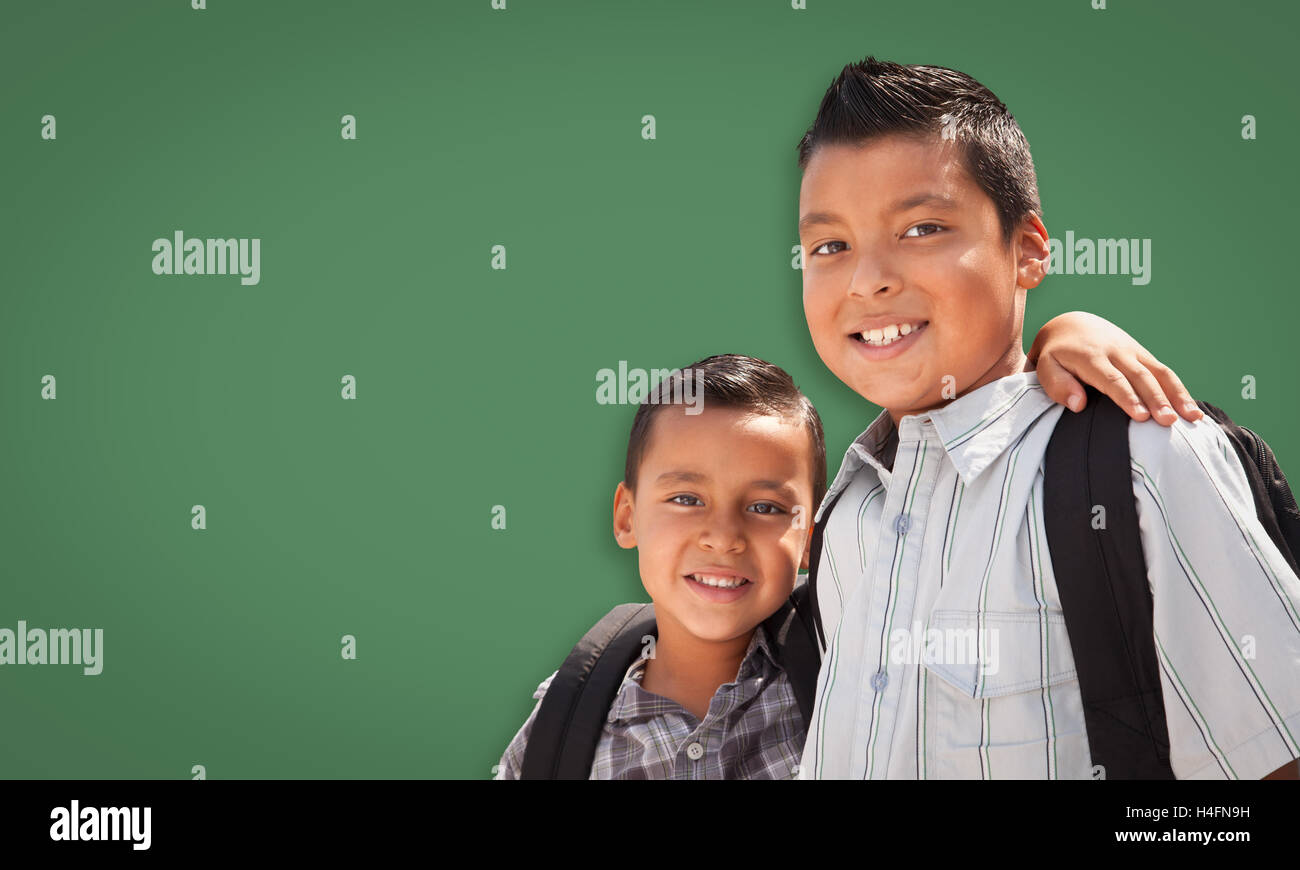 Cute Hispanic Boys Wearing Backpacks In Front of Blank Chalk Board ...