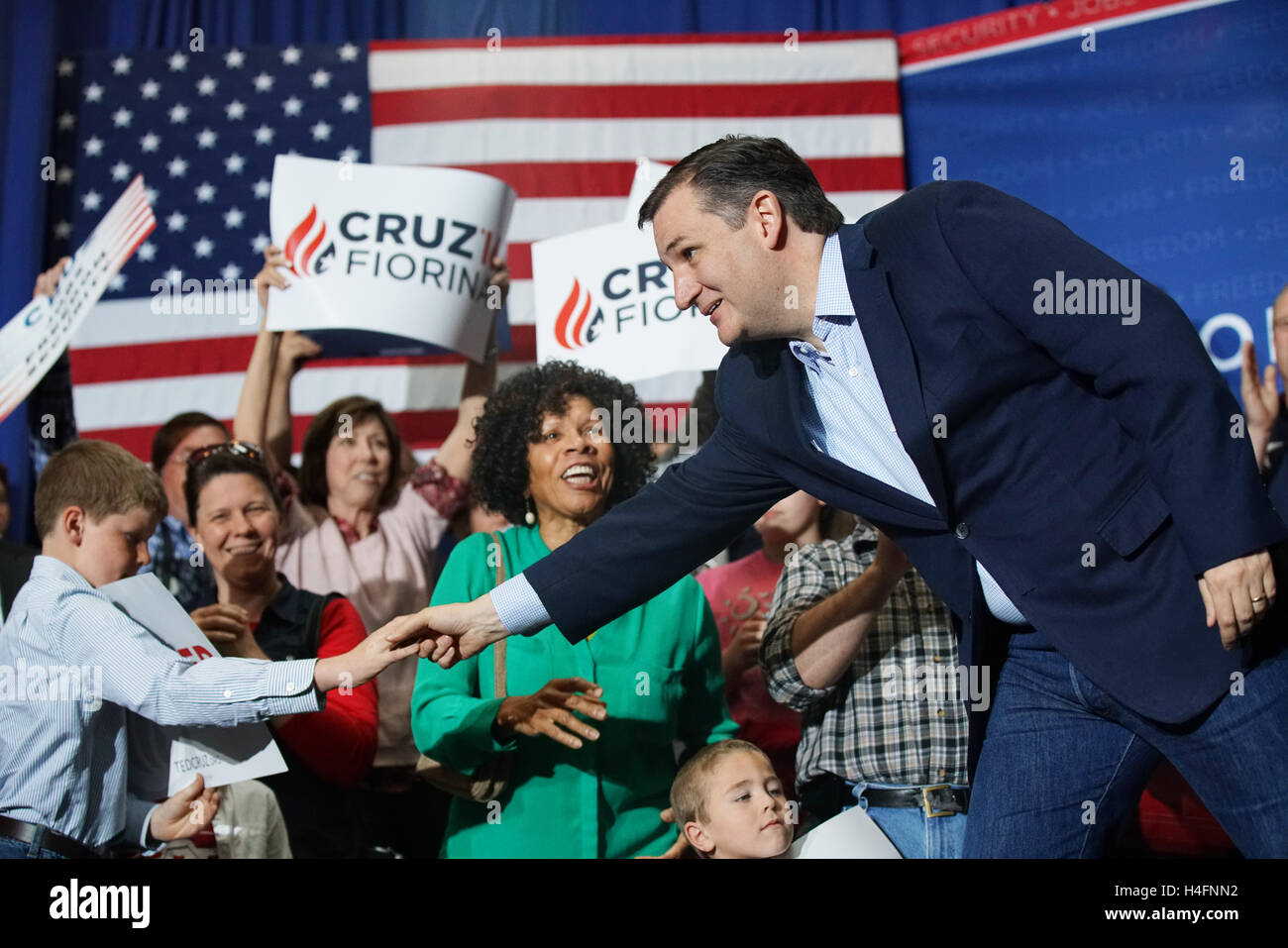 Senator Ted Cruz shakes hands with a kid on stage with supporters ...