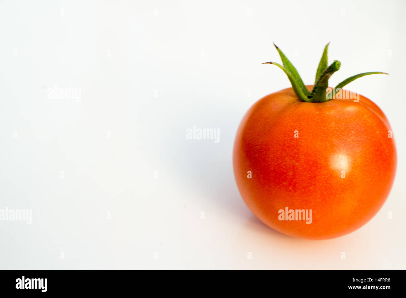Side view of a red tomato with a green stem Stock Photo - Alamy