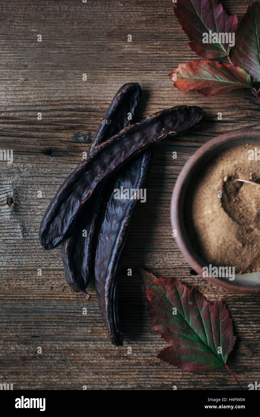 Carob pods and carob powder on wooden table Stock Photo - Alamy