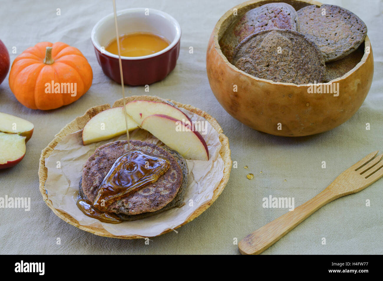 Rustic meal of buckwheat pancakes in plate and bowl made of gourds, on ...