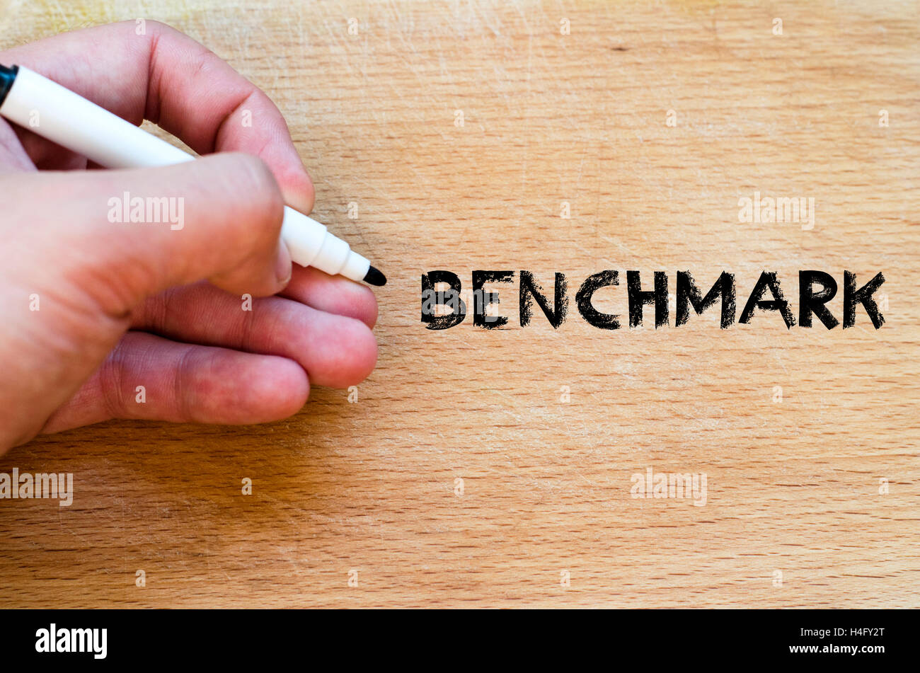 Human hand over wooden background and benchmark text concept Stock ...
