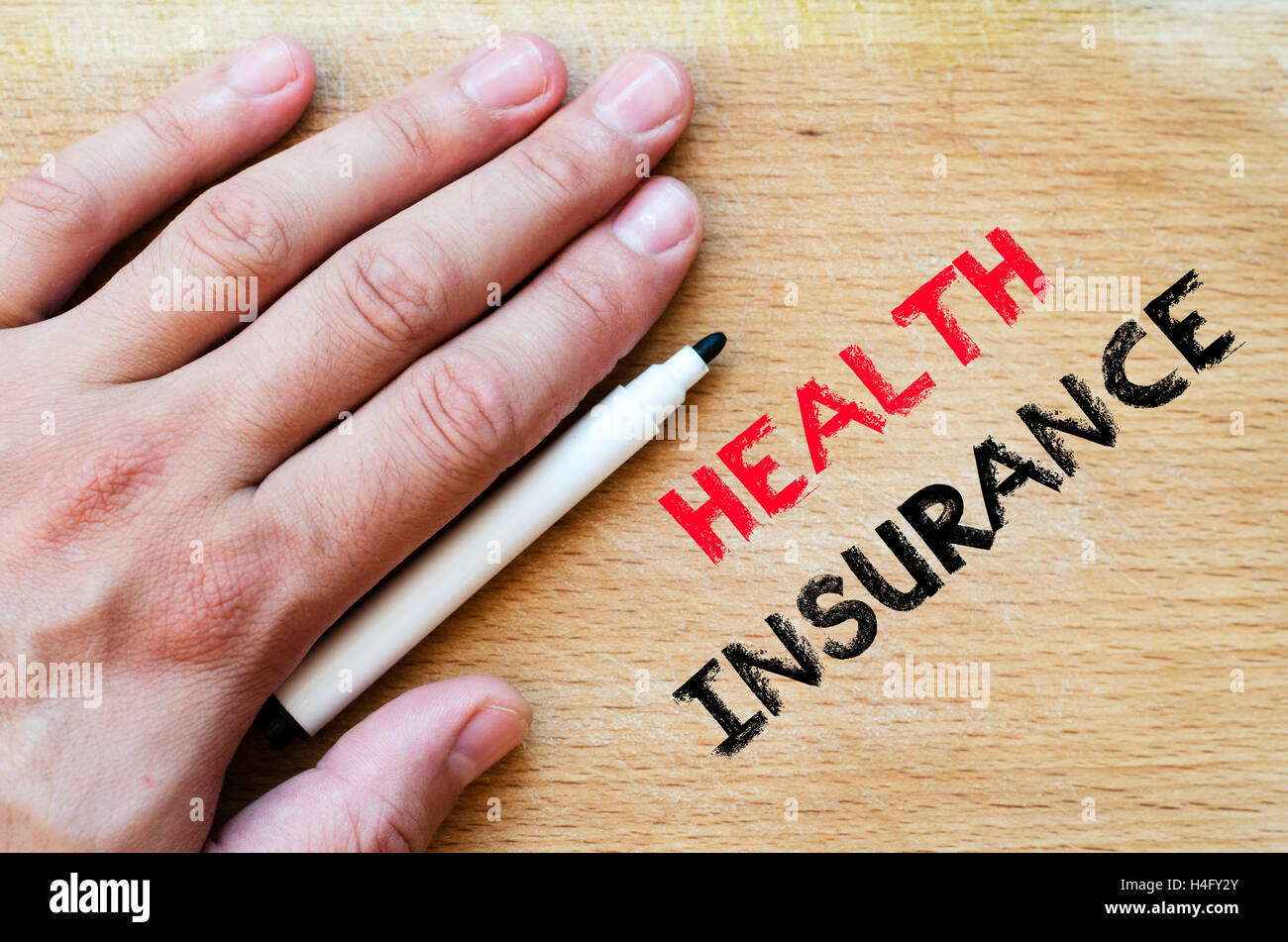 Human hand over wooden background and health insurance text concept ...
