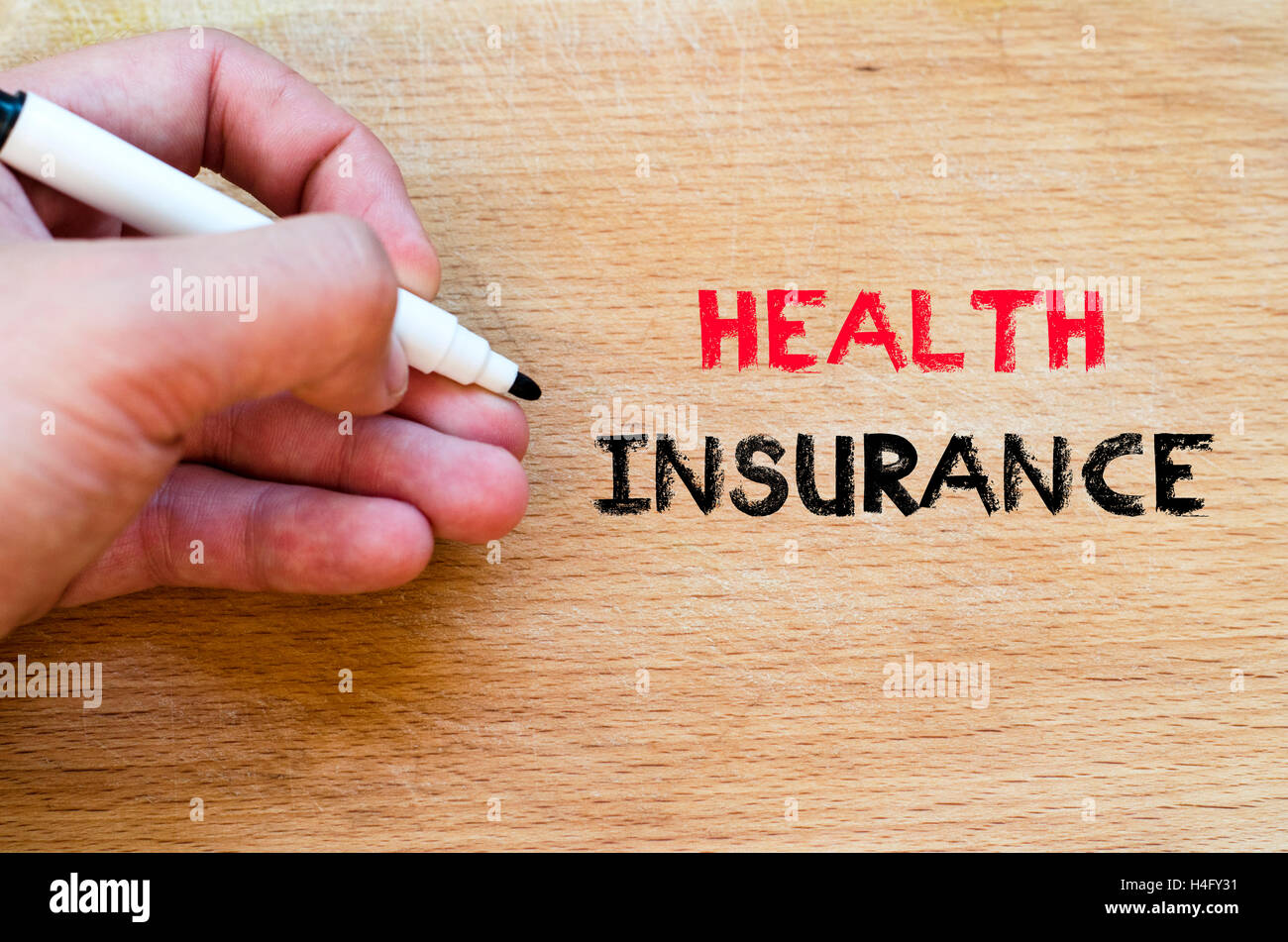 Human hand over wooden background and health insurance text concept ...