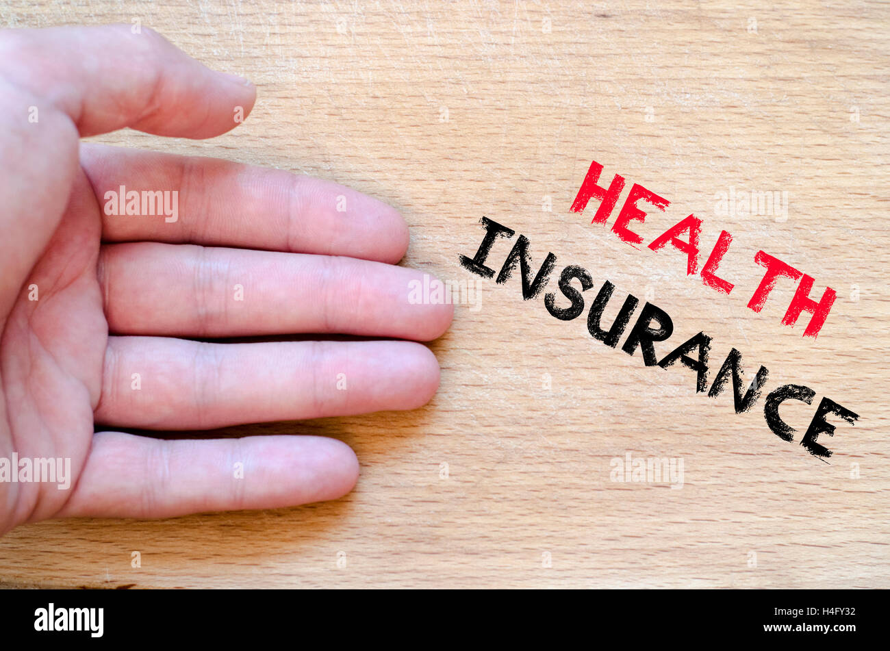 Human hand over wooden background and health insurance text concept ...