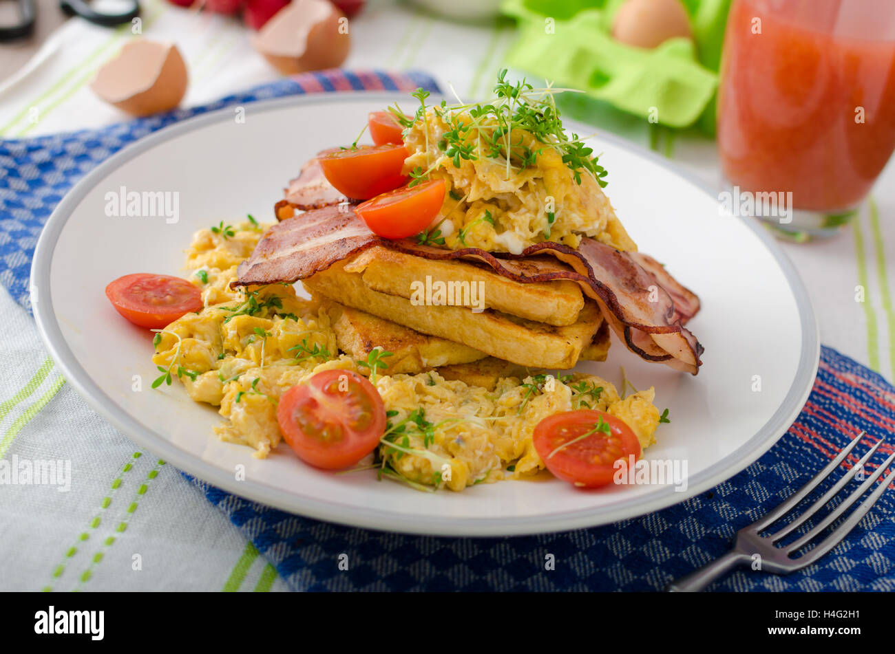 Scrambled eggs with bacon and French toast, tomato and microgreens ...