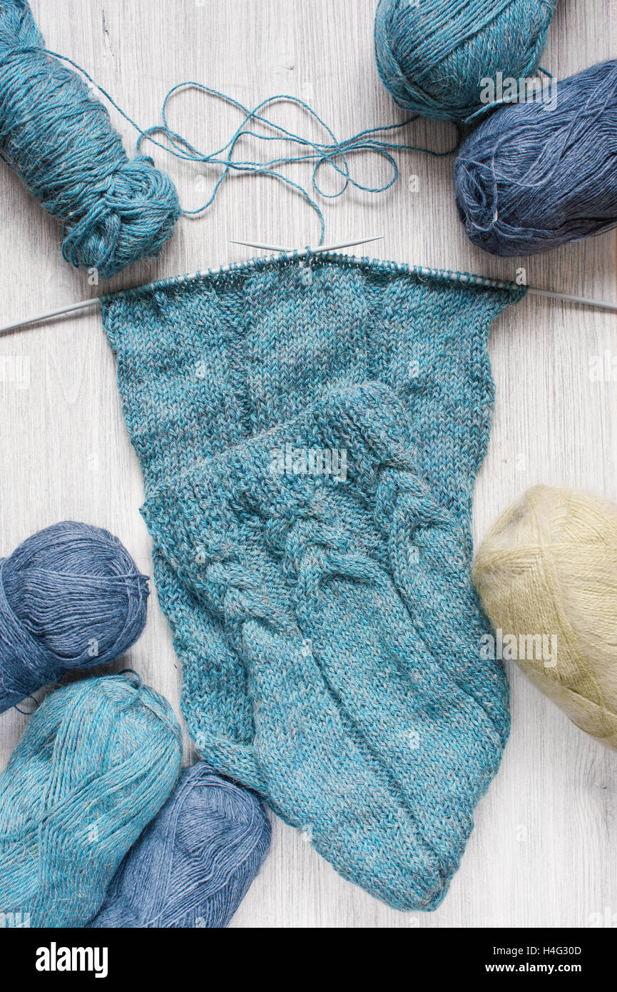 Knitted blue scarf and skeins of wool on the wooden table Stock Photo ...