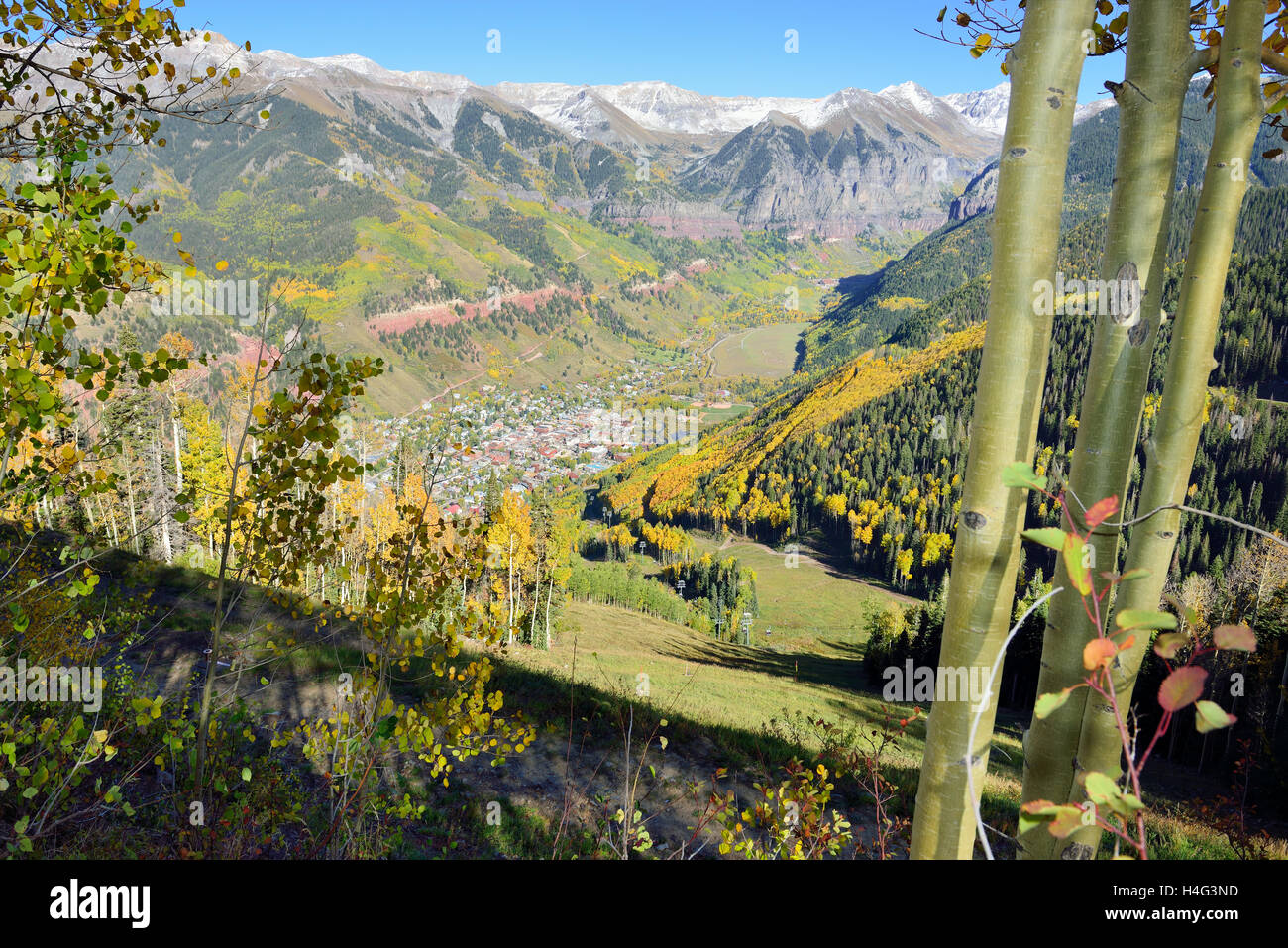 view of Telluride in the fall with yellow aspen and snow covered ...