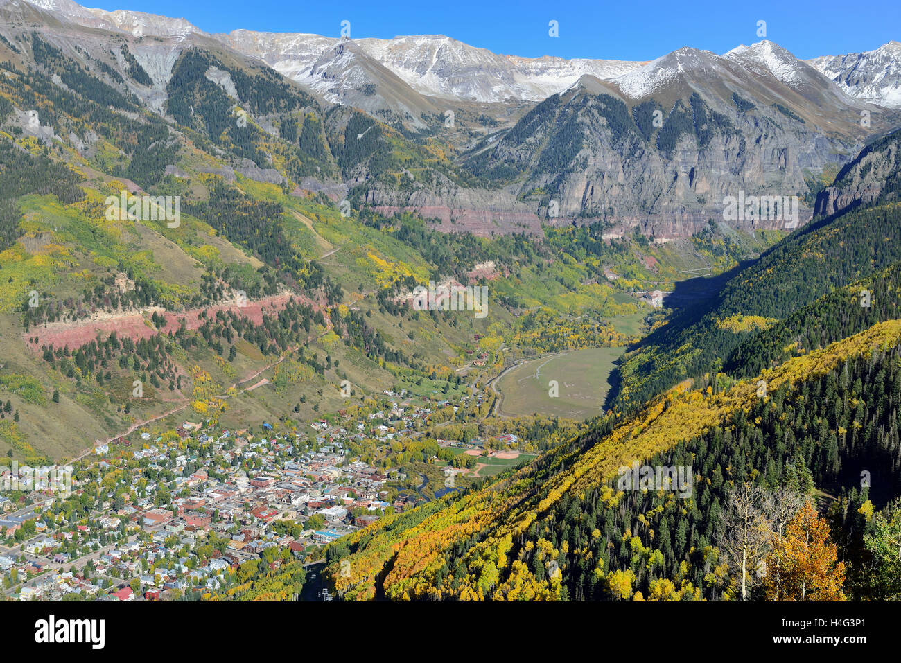 view of Telluride in the fall with yellow aspen and snow covered ...