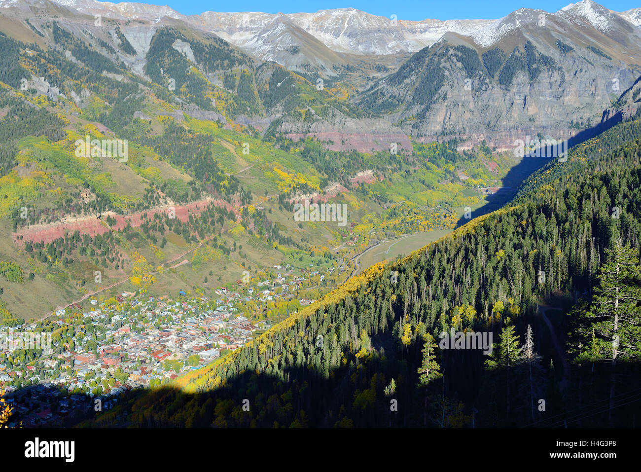 view of Telluride in the fall with yellow aspen and snow covered ...