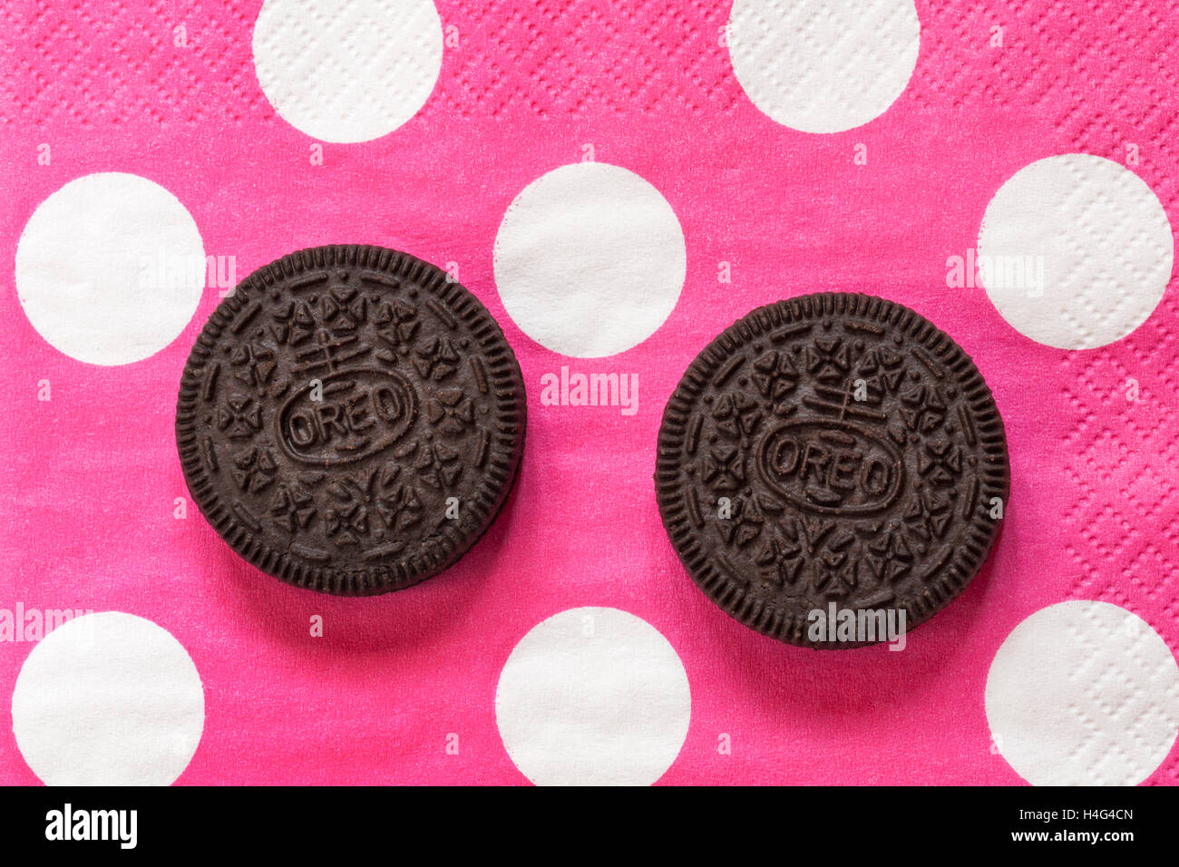 Two Strawberry Cheesecake flavour Oreo biscuits on pink polka dots ...