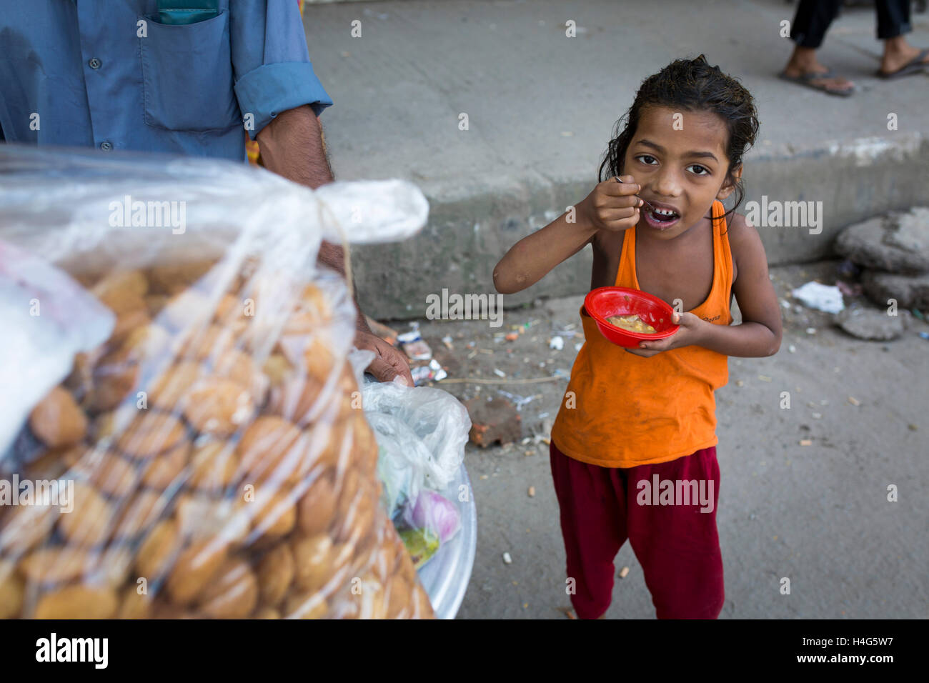 DHAKA, BANGLADESH - OCTOBER 15 : A child eating street food in Dhaka ...