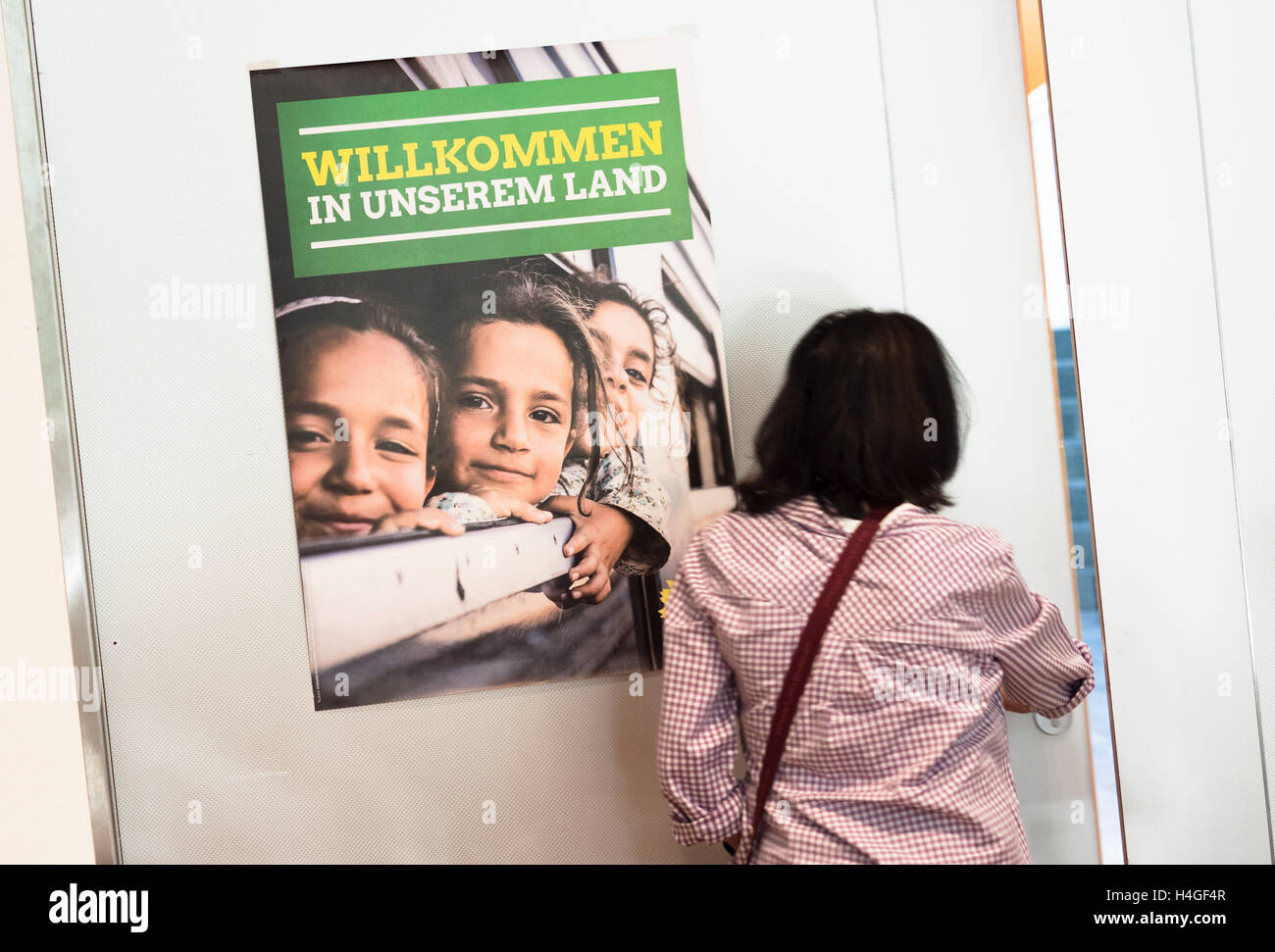 A delegate walks past a poster reading 'Welcome to our country' at the ...