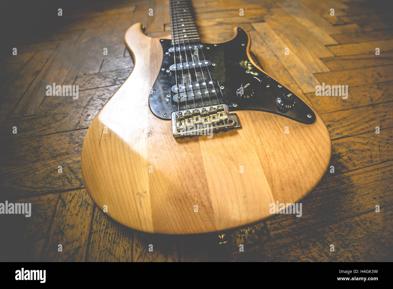 Old dirty electric guitar on basement floor Stock Photo - Alamy