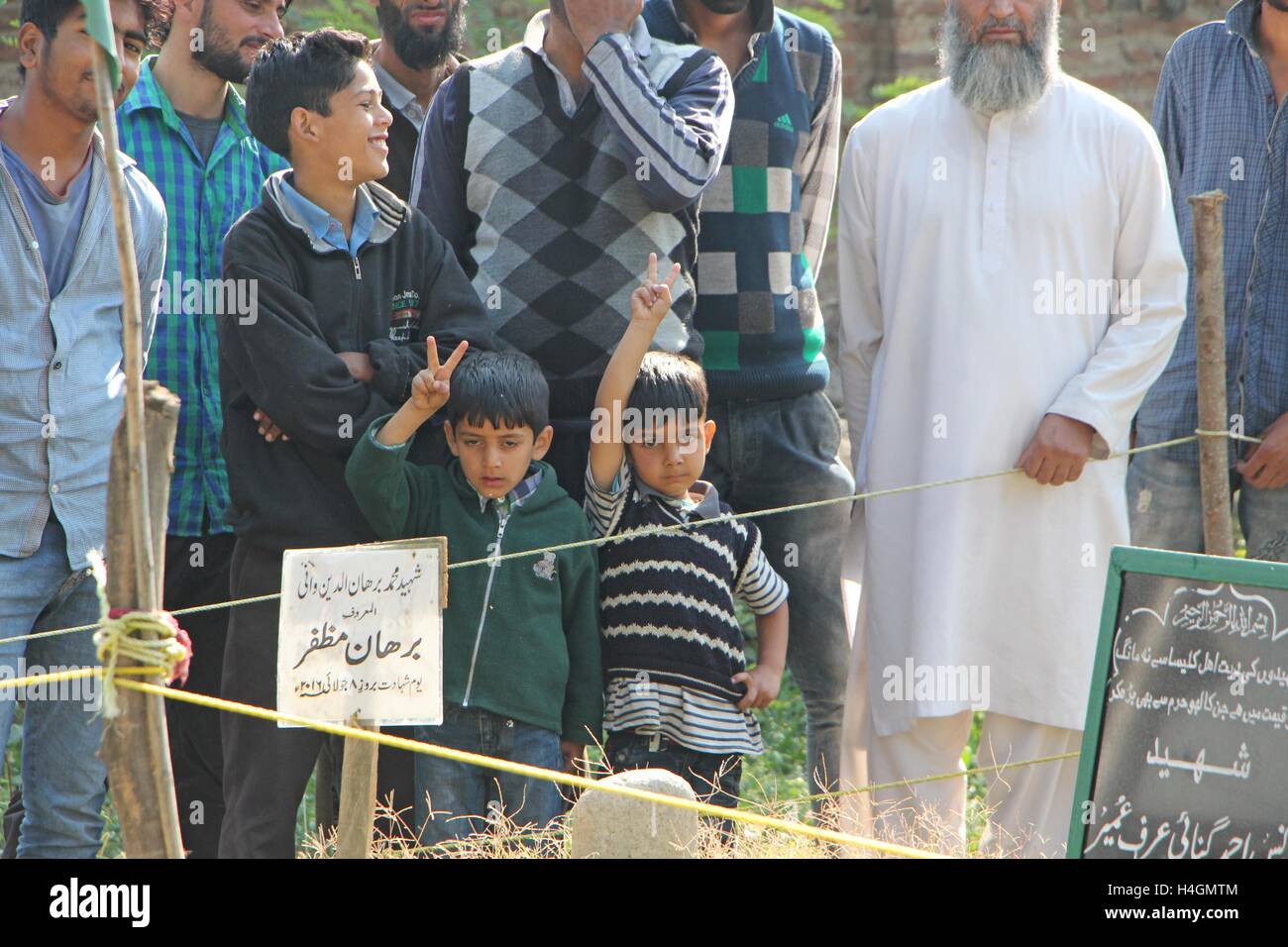 Kids pose near the grave of rebel commander Burhan Wani in Shareef Abad ...