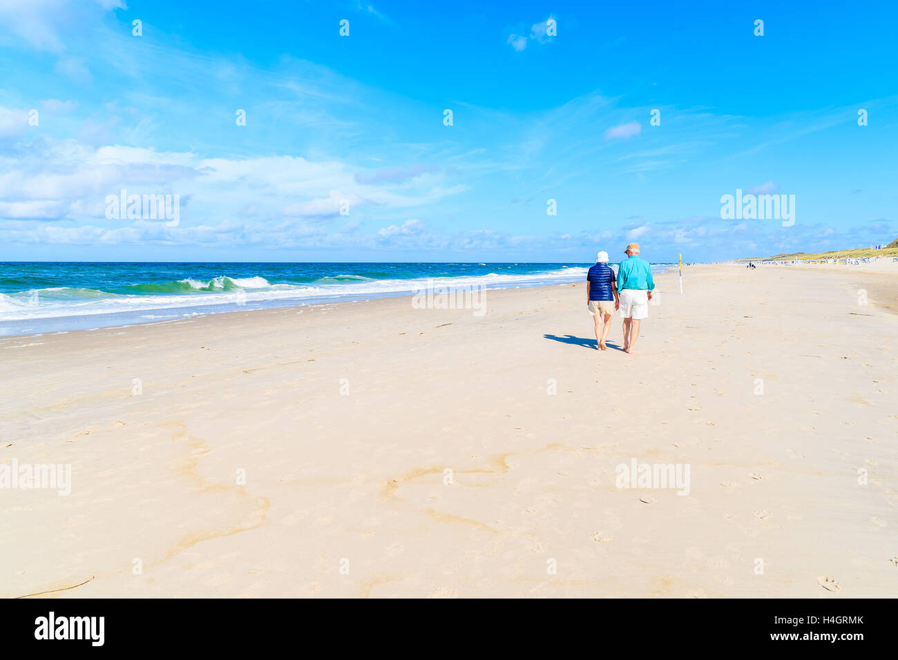 Unidentified couple of elderly people walking along sea on beautiful ...