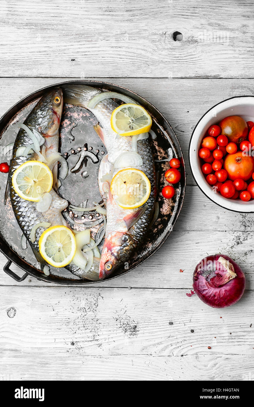 Two carcasses of raw marine fish in seasonings and tomatoes Stock Photo ...