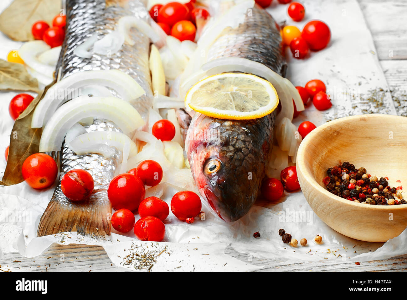 Two carcasses of raw marine fish in seasonings and tomatoes Stock Photo ...