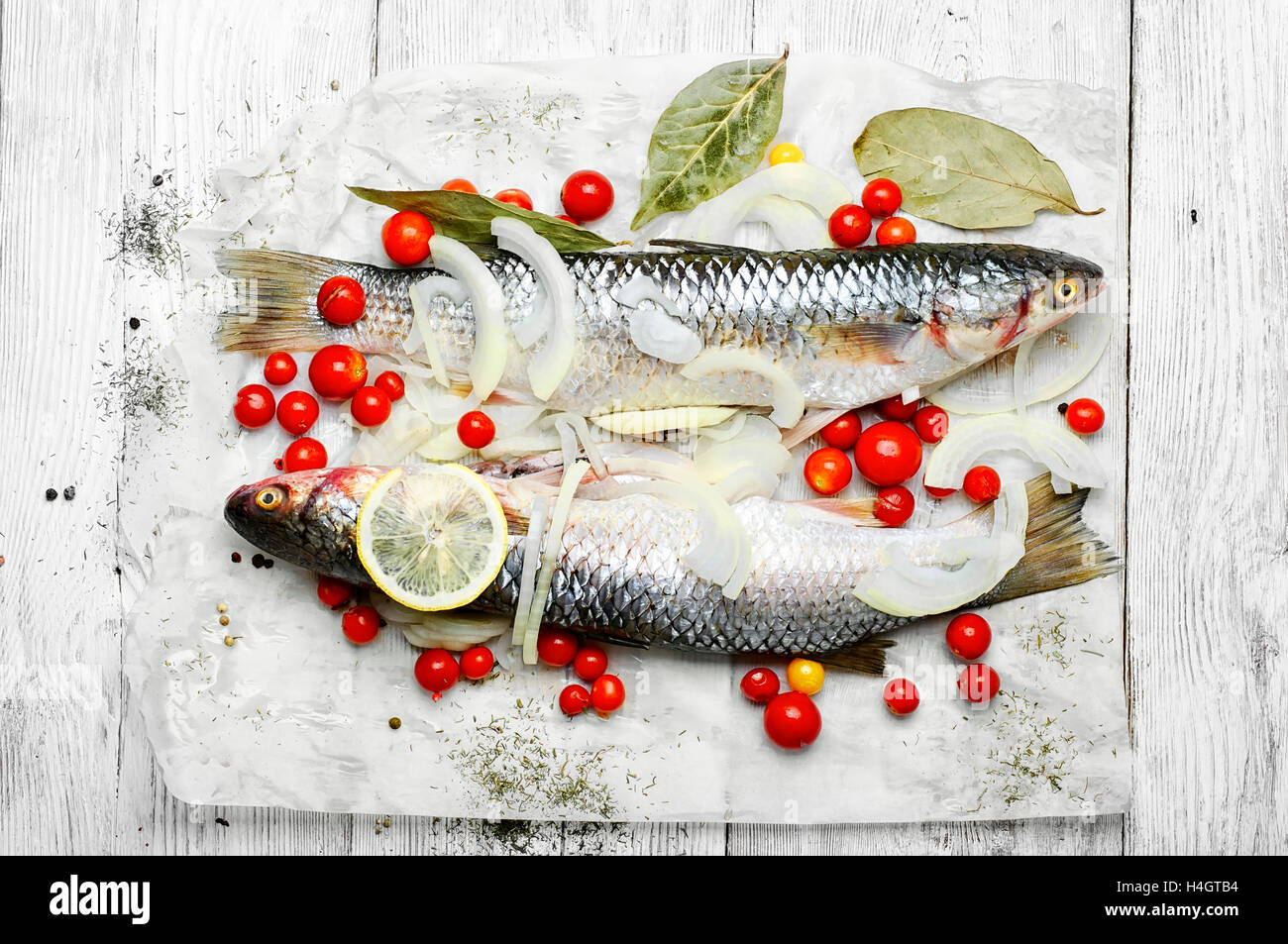 Two carcasses of raw marine fish in seasonings and tomatoes Stock Photo ...