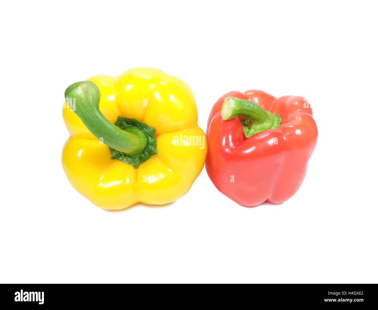 Close-up of two ripe bell peppers, yellow and red with green stem ...