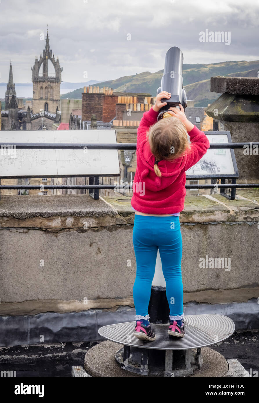 Little girl stretching to to be able to look through the telescope on ...