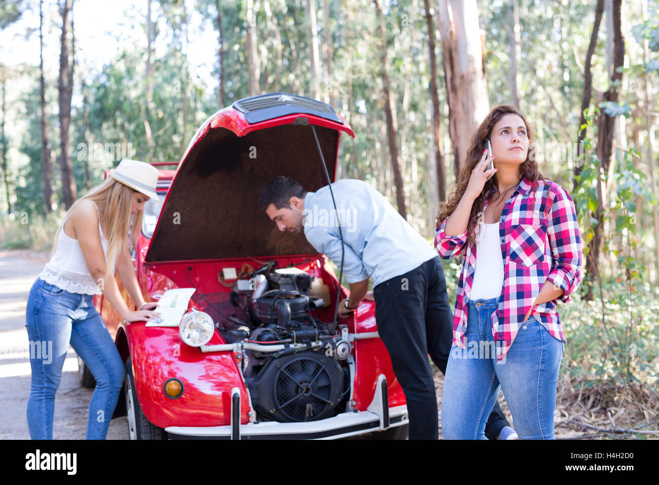 Friends on a roadtrip having a problem with their old car Stock Photo ...