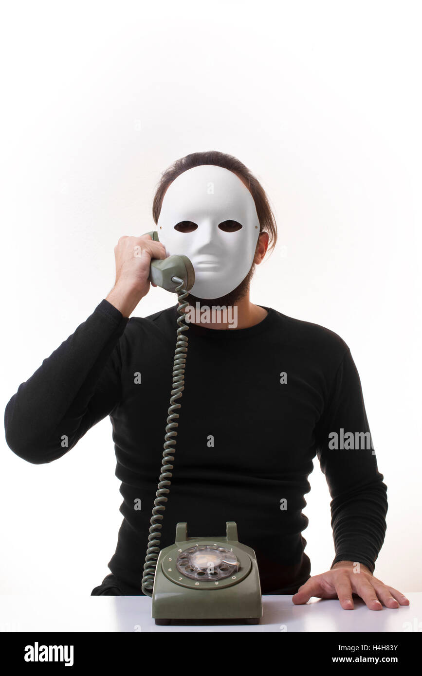 The man with mask talking with an old phone.Its an anonymous phone call ...