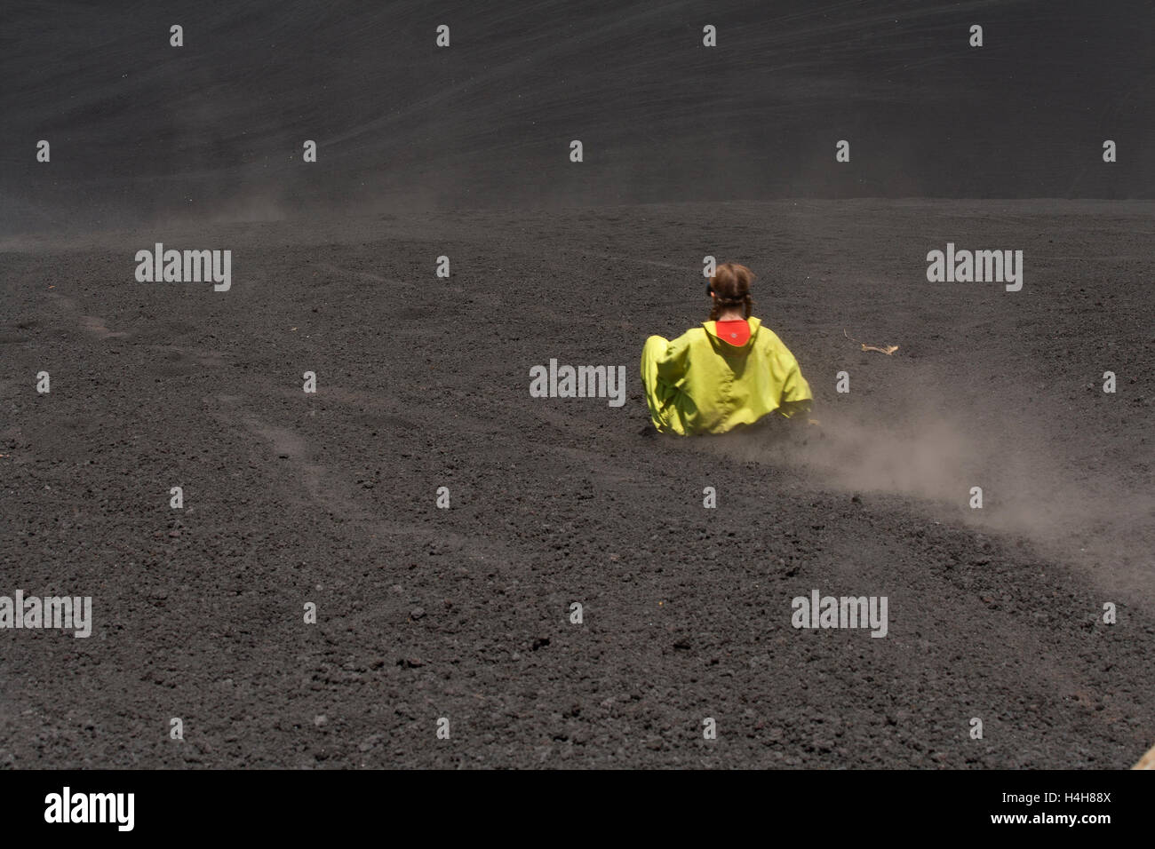 A girl volcano boarding her way down a black rock volcano Stock Photo ...