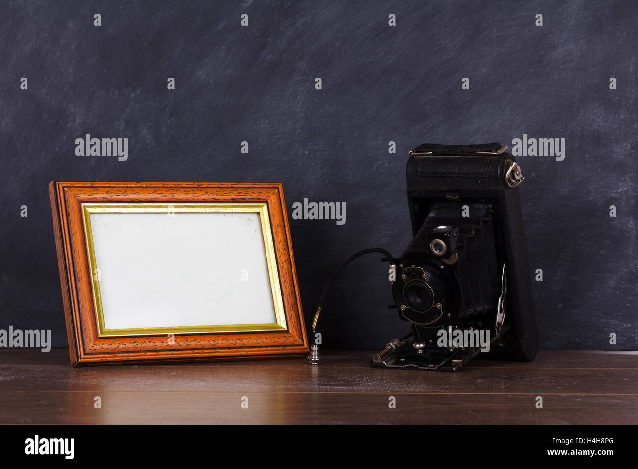Old vintage camera and frame against blackboard background Stock Photo ...