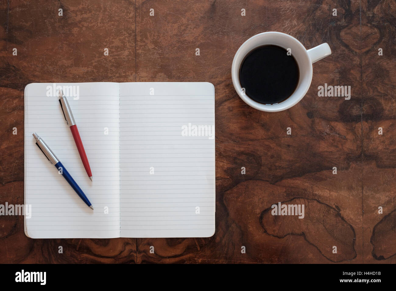 pens on a copy book isolated on wooden background Stock Photo - Alamy