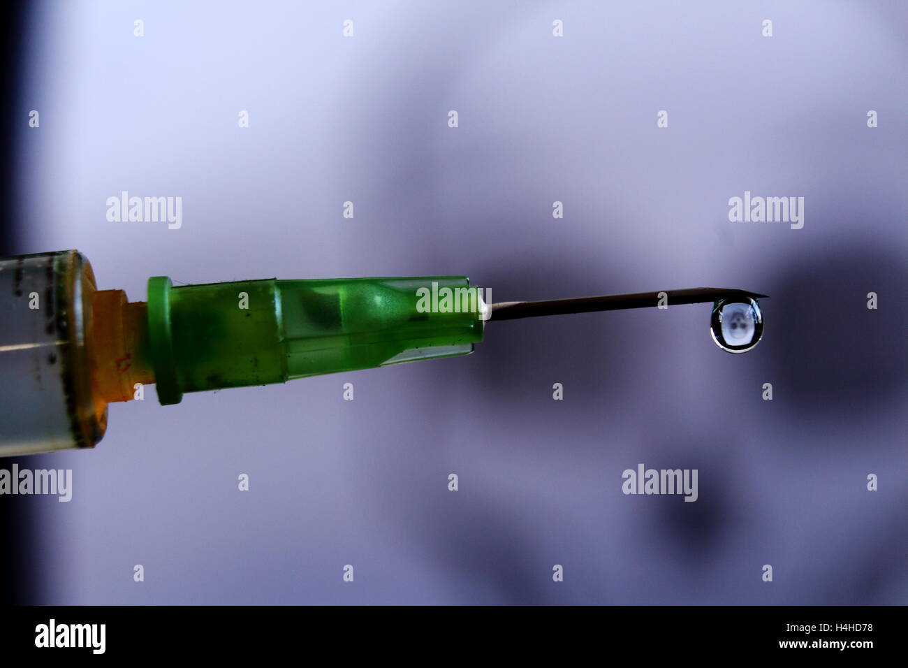 hypodermic syringe with picture of skull in water drop Stock Photo - Alamy
