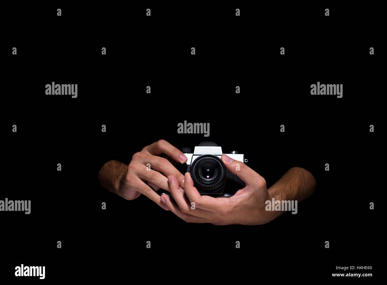 Retro camera in the human hands. Isolated on black background Stock ...