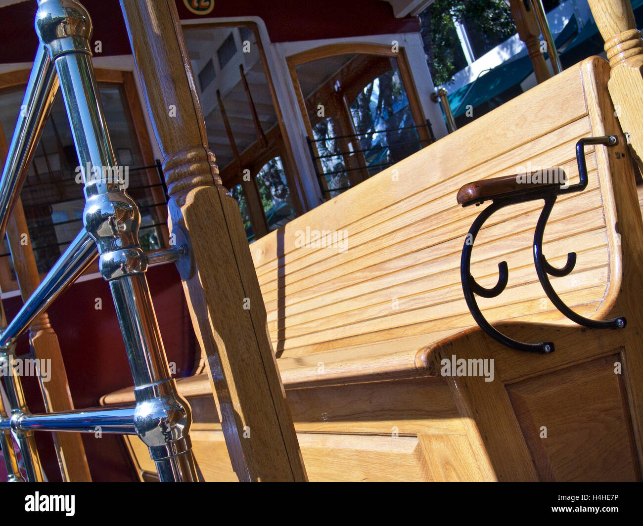 Sunlit wooden bench and rails on traditional cable car in San Francisco ...