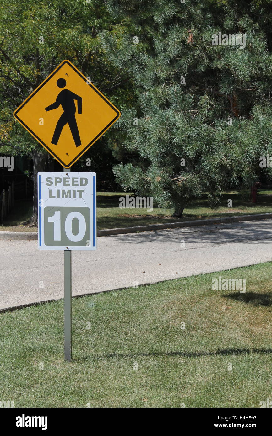 A speed limit sign and pedestrian crossing sign in a parking lot Stock ...