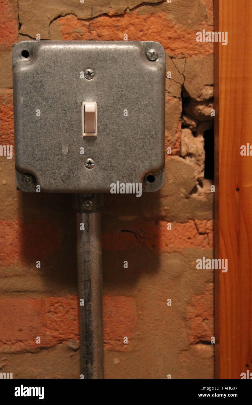 A bare light switch on a brick wall Stock Photo - Alamy