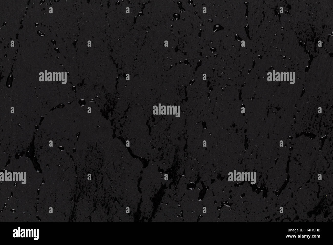 Water drops on dark stone rock surface of basalt or granite Stock Photo ...