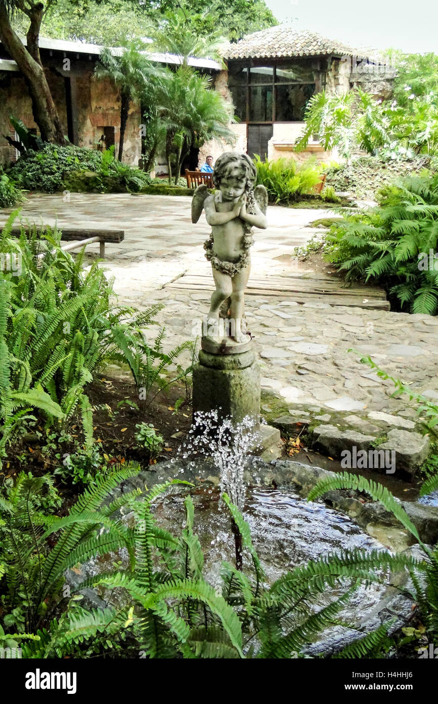 Fountain stone angel statue in a pond in a botanical garden in Antigua ...