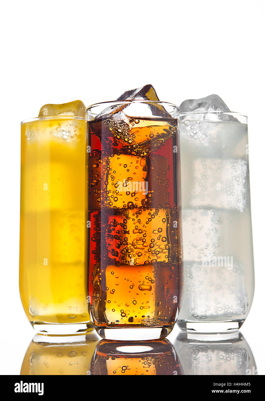 Glasses with cola orange soda and lemonade with ice cubes and reflection on white background ...