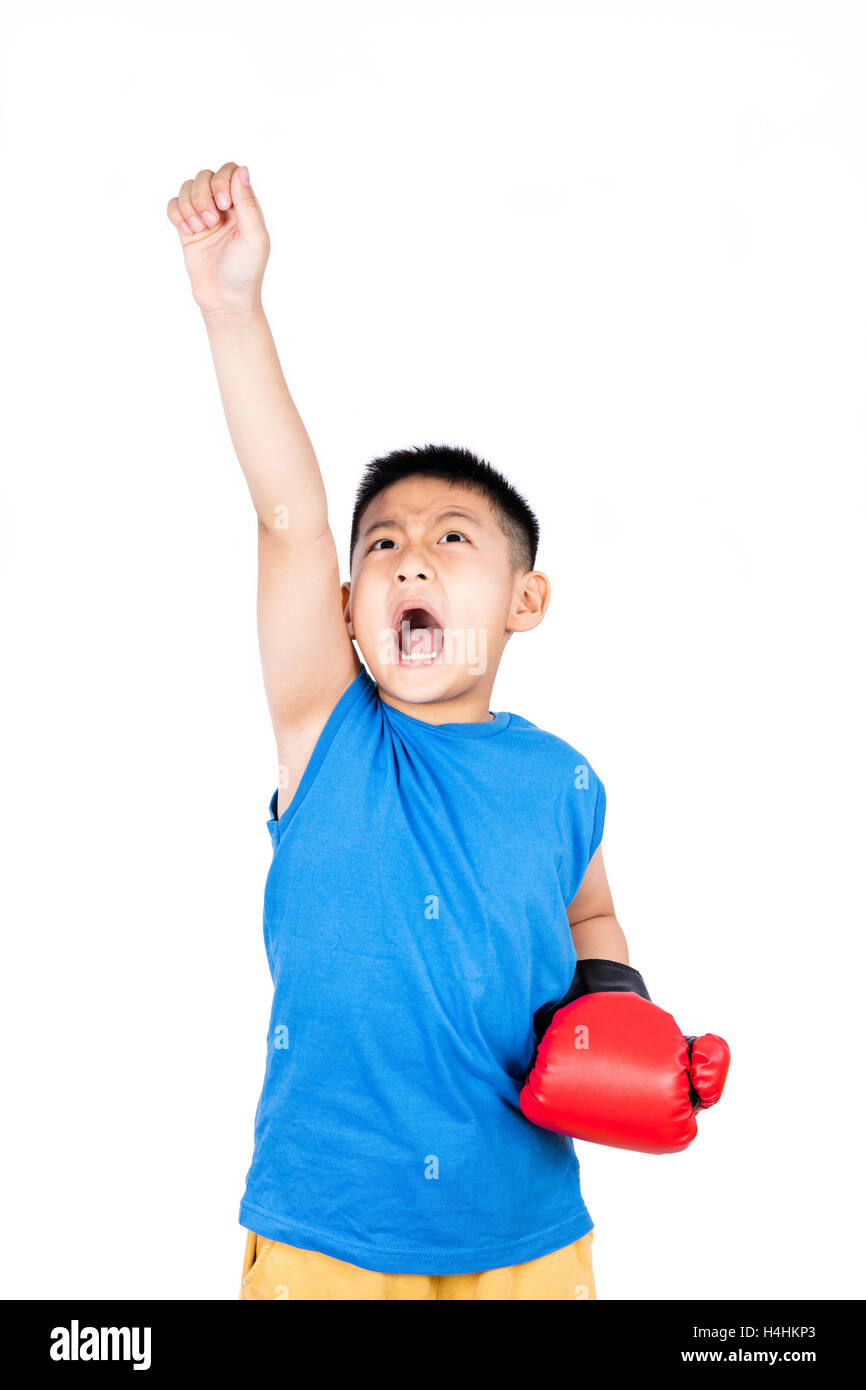 Asian Chinese boy wearing boxing gloves with victory in isolated plain ...