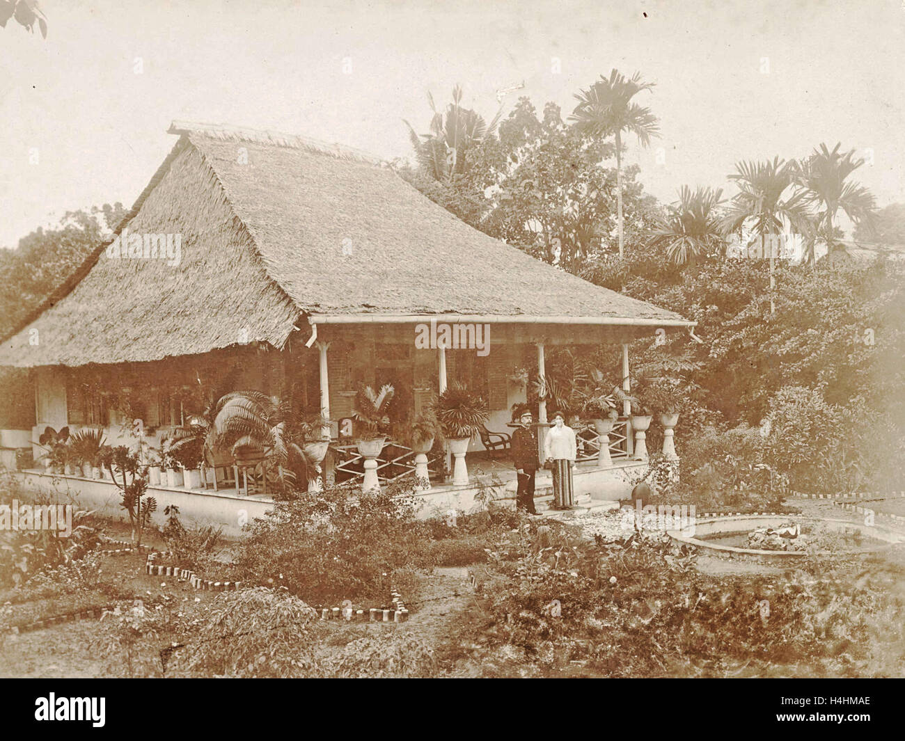 Man and woman posing for a house with a garden in Ambon, Indonesia ...